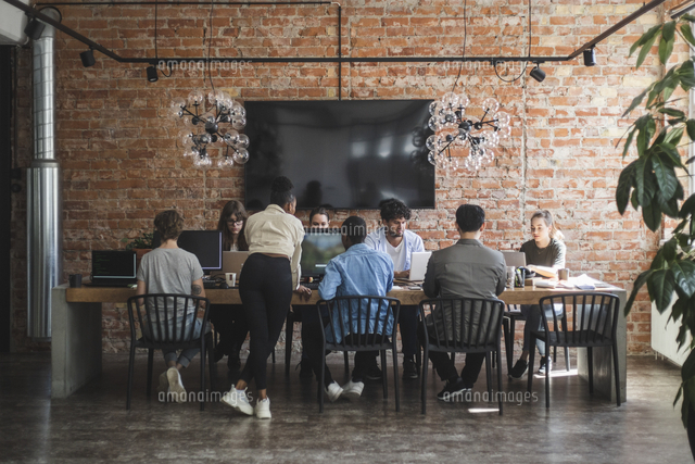 Multi-ethnic male and female hackers working on computer in creative ...