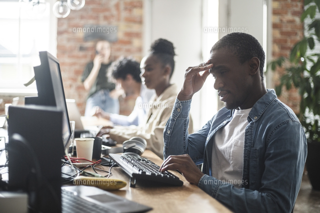Multi-ethnic male and female hackers working at office[11081042010]の写真 ...