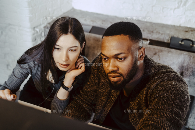 High angle view of male and female programmers discussing over computer ...
