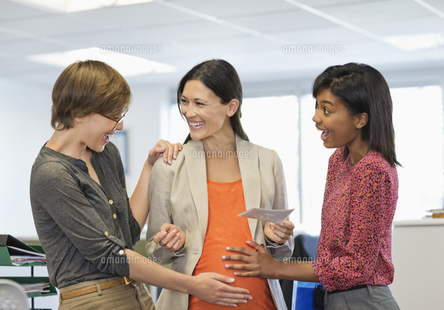 Colleagues admiring pregnant businesswoman’s belly[11086043490]の写真素材 ...