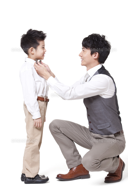 Smiling father fastening bow tie for son[11091000955]の写真素材・イラスト素材｜アマナイメージズ