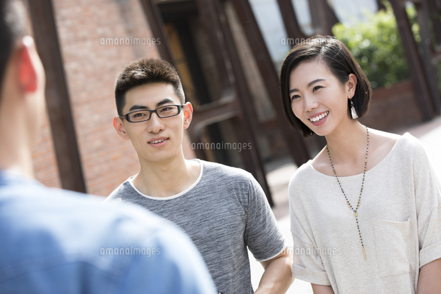 Cheerful young Chinese friends talking outdoors[11091026048]の写真素材・イラスト ...