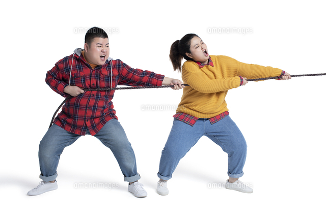 Young Chinese couple pulling rope[11091036991]の写真素材・イラスト素材｜アマナイメージズ