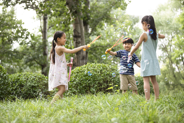 Three Chinese children blowing bubbles on grass[11091044182]の写真素材・イラスト ...