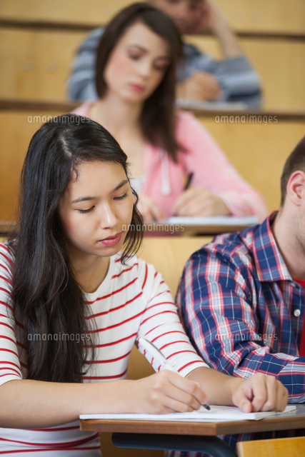 Focused asian student taking notes in lecture[11092002376]の写真素材・イラスト素材 ...