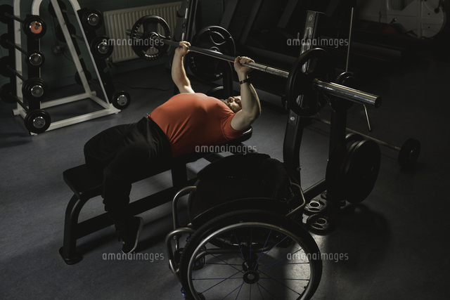Handicapped man doing chest workout on bench press with barbell ...
