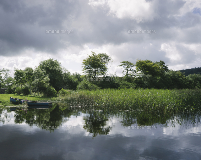 Blue wooden rowboat lying on the shore of Glenade Lake, Glenade, County ...