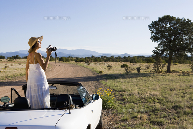 Native American woman in sun dress driving a white convertible sports ...