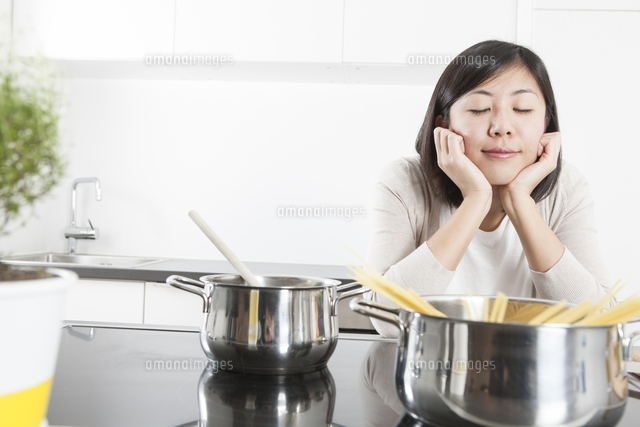 Portrait of smiling young woman relaxing while cooking[11094008351]の写真 ...