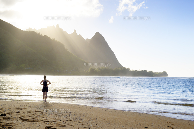 USA, Hawaii, Hanalei, woman standing on Haena Beach, View to ...