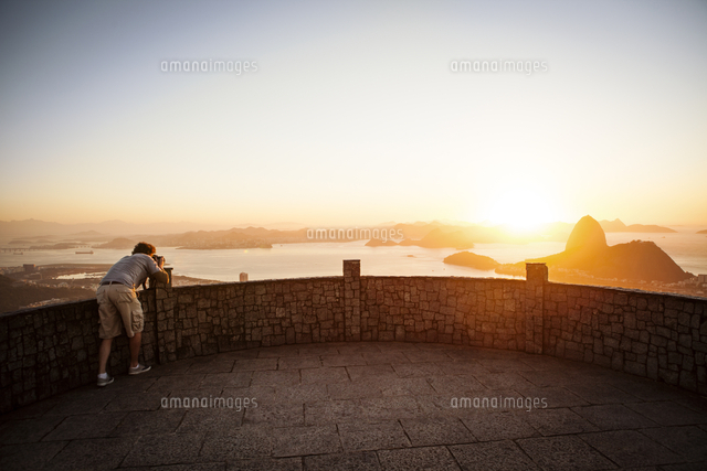 Man photographing seaside sunrise from observation point[11100012515]の ...