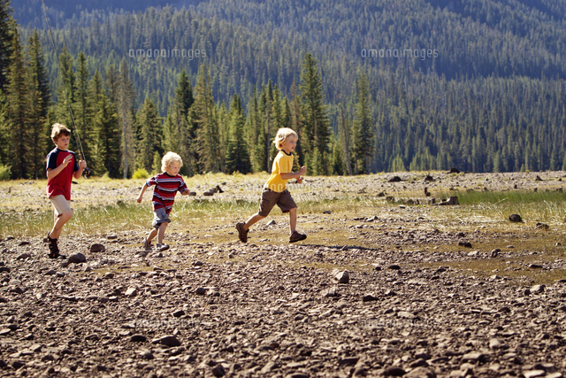 Three brothers running in field[11100012752]の写真素材・イラスト素材｜アマナイメージズ