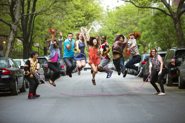Young people jumping over skipping rope on city street[11100026903]の写真 ...