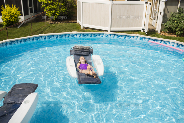 Happy girl relaxing on inflatable raft in swimming pool[11100041687]の写真 ...