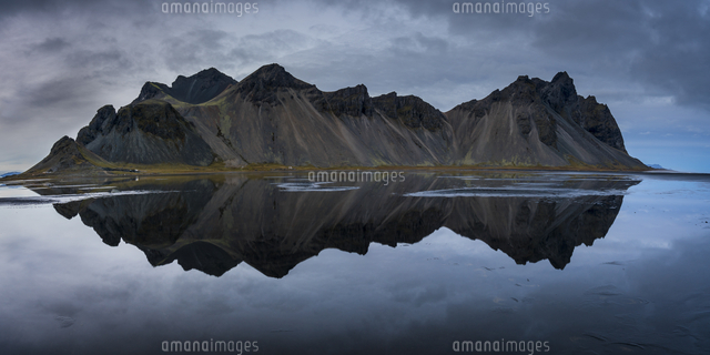 Reflection of Vestrahorn mountain range on ocean at Stokksnes, Iceland ...