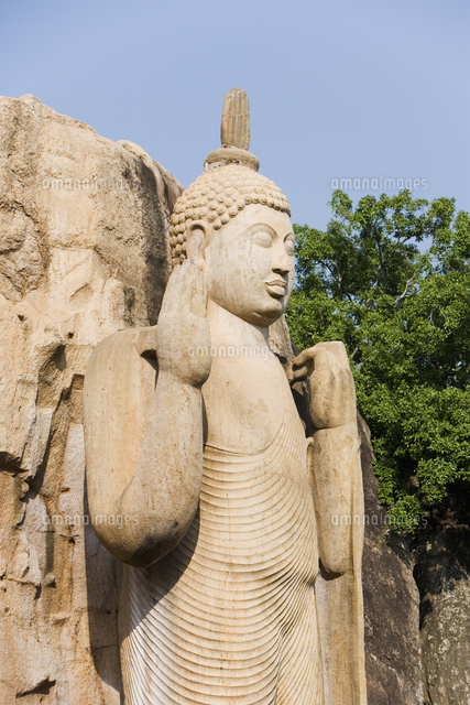 Giant standing statue of the Buddha, his right hand raised in blessing ...
