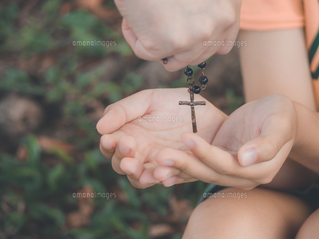 Cropped Hand Giving Cross To Woman[11115258525]の写真素材・イラスト素材｜アマナイメージズ