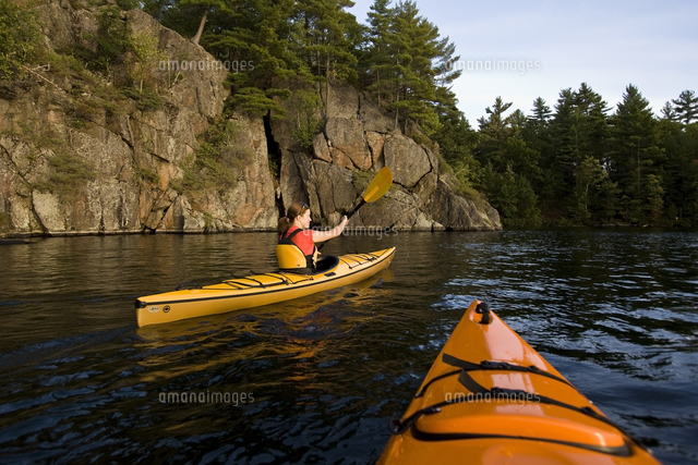 Young woman sea kayaking through Gull Narrows near Gravenhurst, Muskoka ...