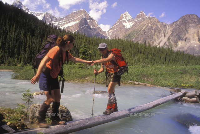 Woman helping another across Eremite Creek, Tonquin Valley, Jasper ...
